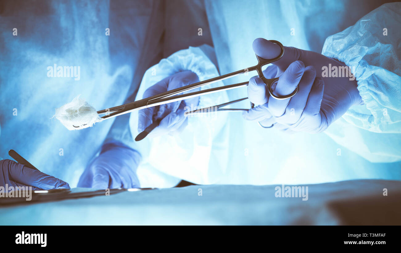 Surgeons hands holding surgical scissors and passing surgical equipment ...