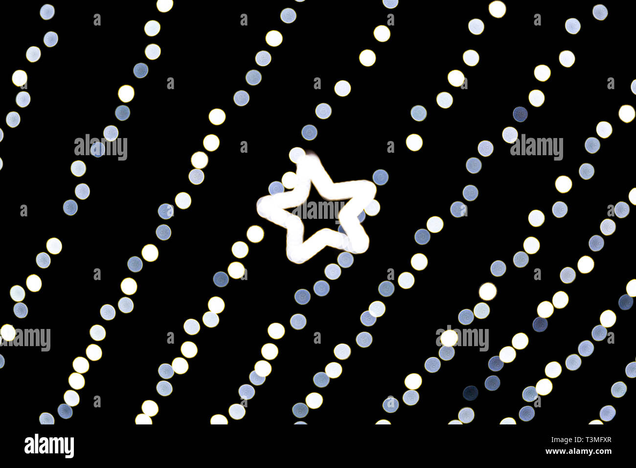 Unfocused abstract white bokeh with star of light on black background ...