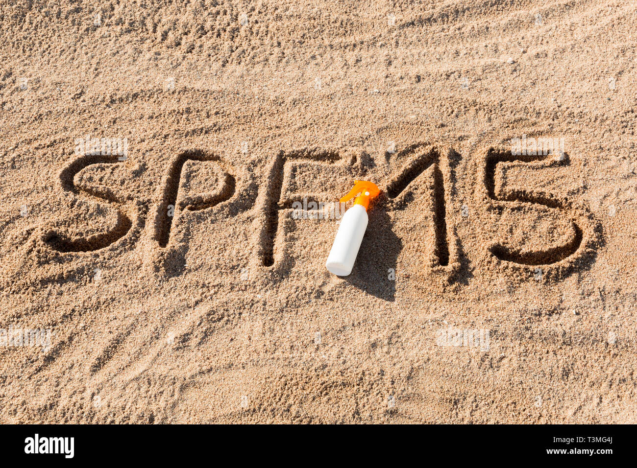 Sun protect factor fifteen. SPF 15 word written on the sand and white ...