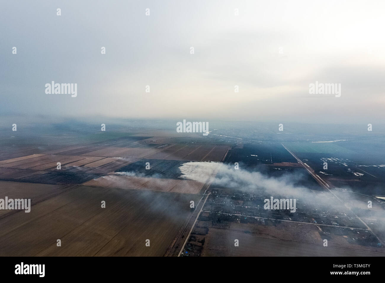 Top view of the small village. Smoke from the burning of straw is ...