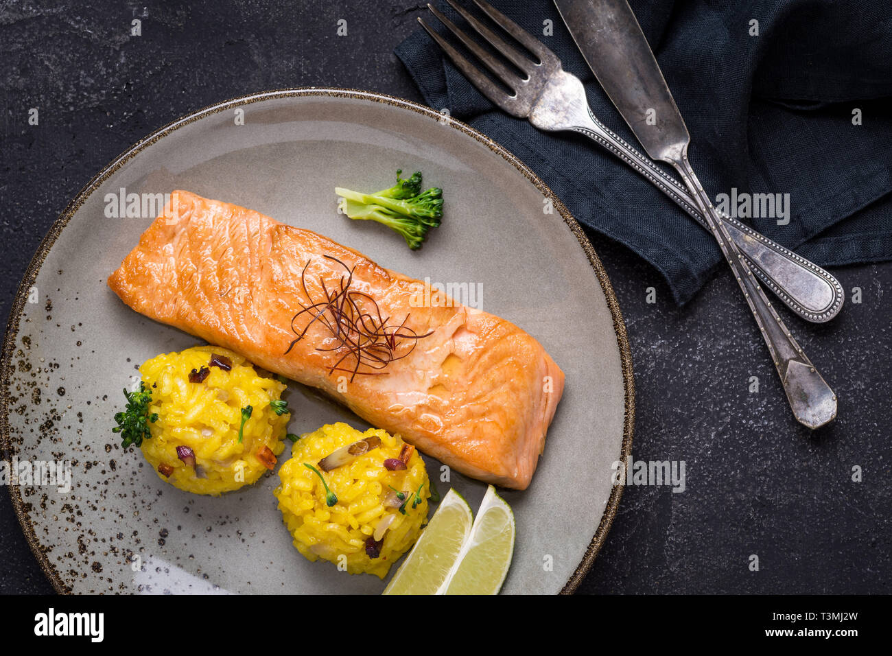 Grilled Salmon Fillet with Saffron Risotto on Dark Background Stock ...