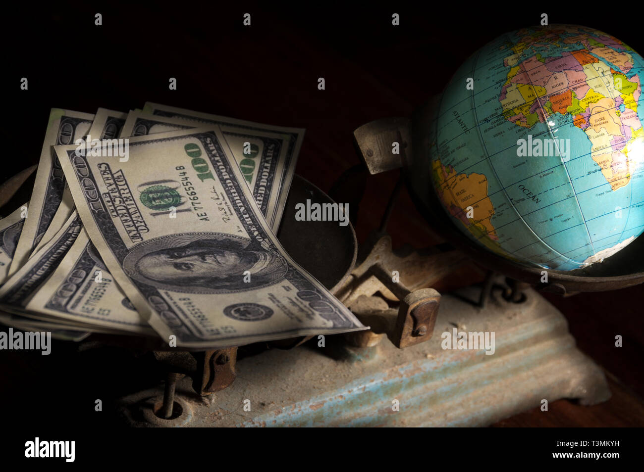 Money and globe on old scale Stock Photo - Alamy