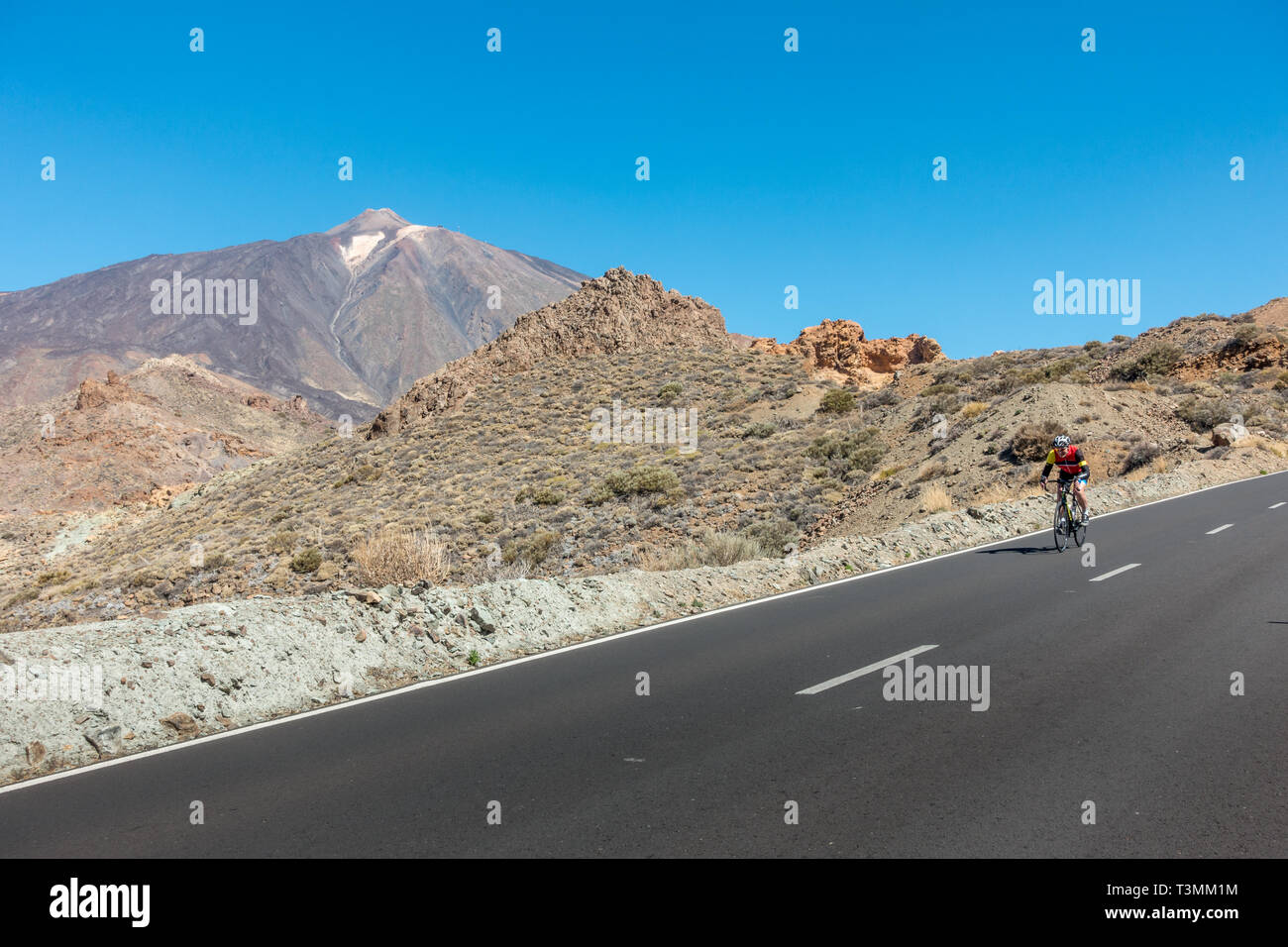 Cyclist on a road bike enjoying the descent from the Mount Teide cable ...