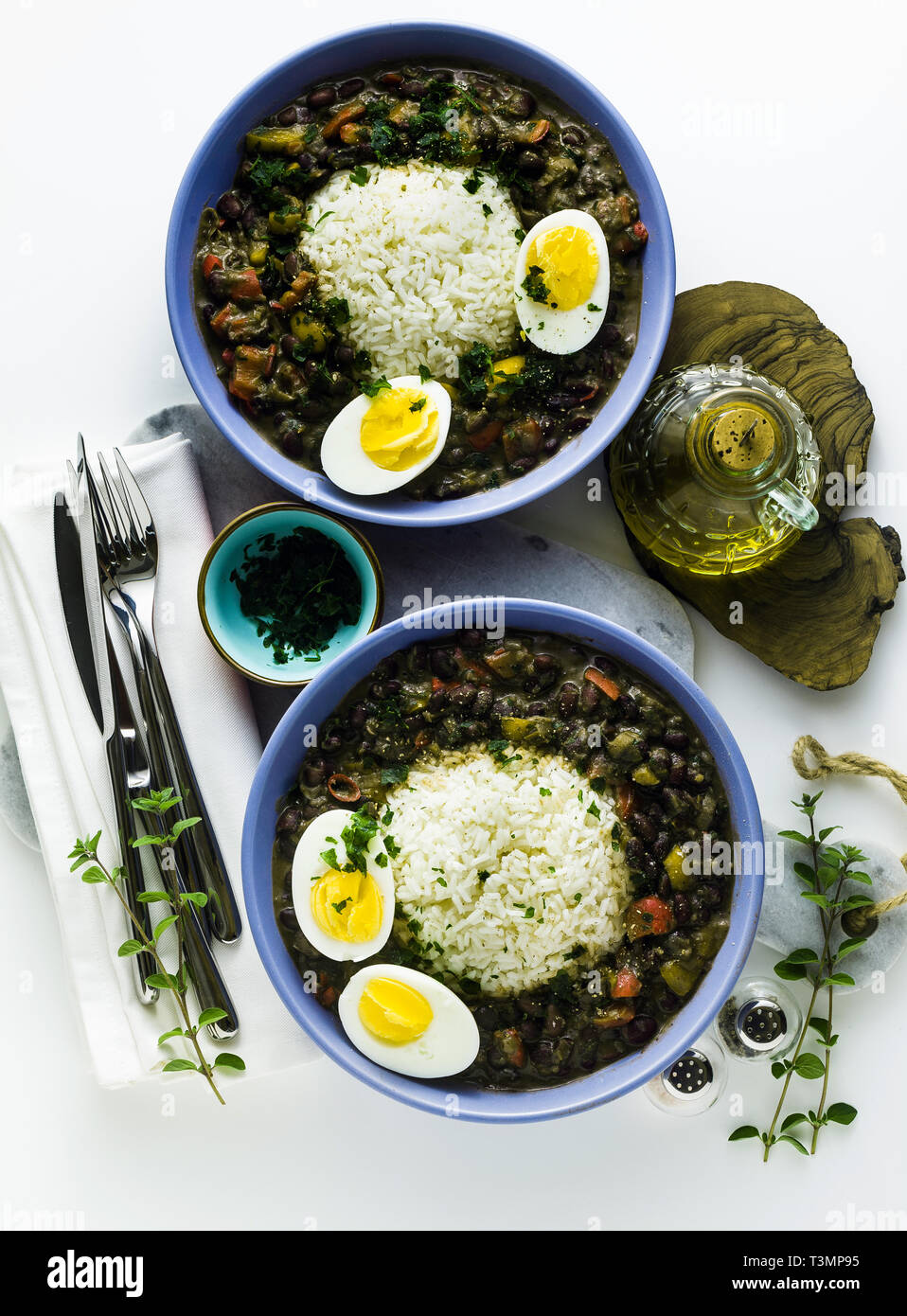 rice with black beans and boiled egg on the table with spices and olive ...