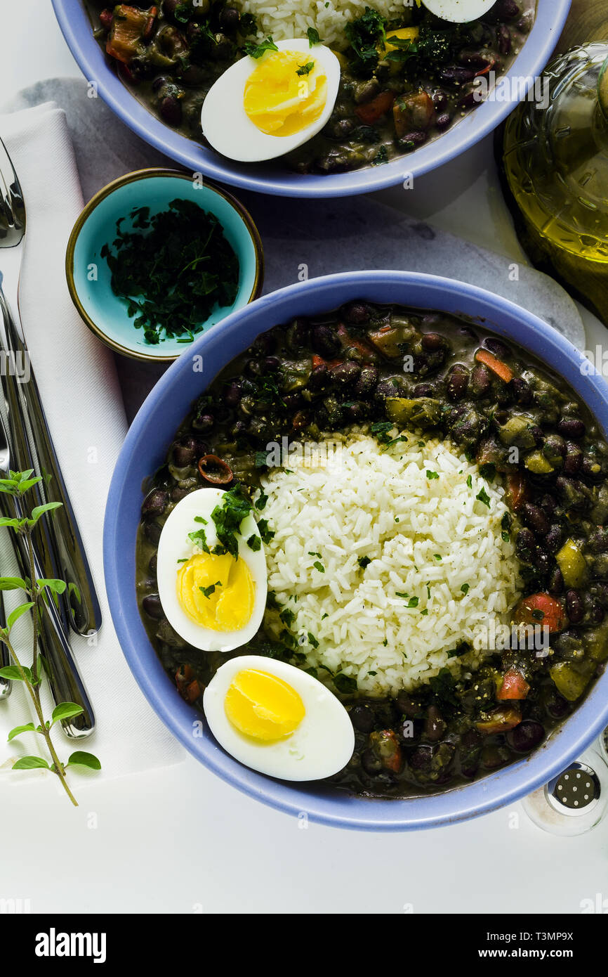 rice with black beans and boiled egg on the table with spices and olive ...