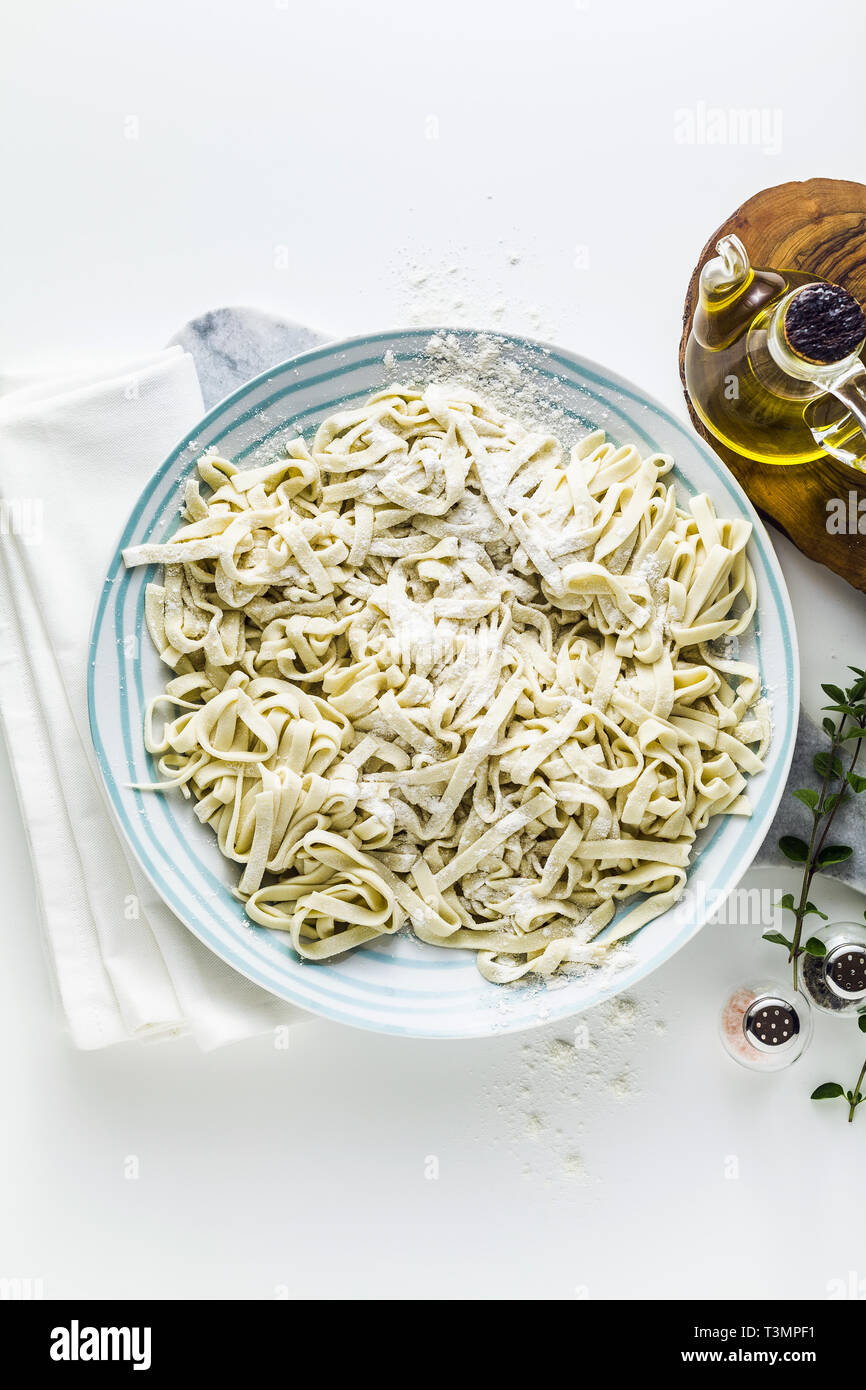 Fresh homemade tagliatelle pasta ready to be cooked. on a white table ...
