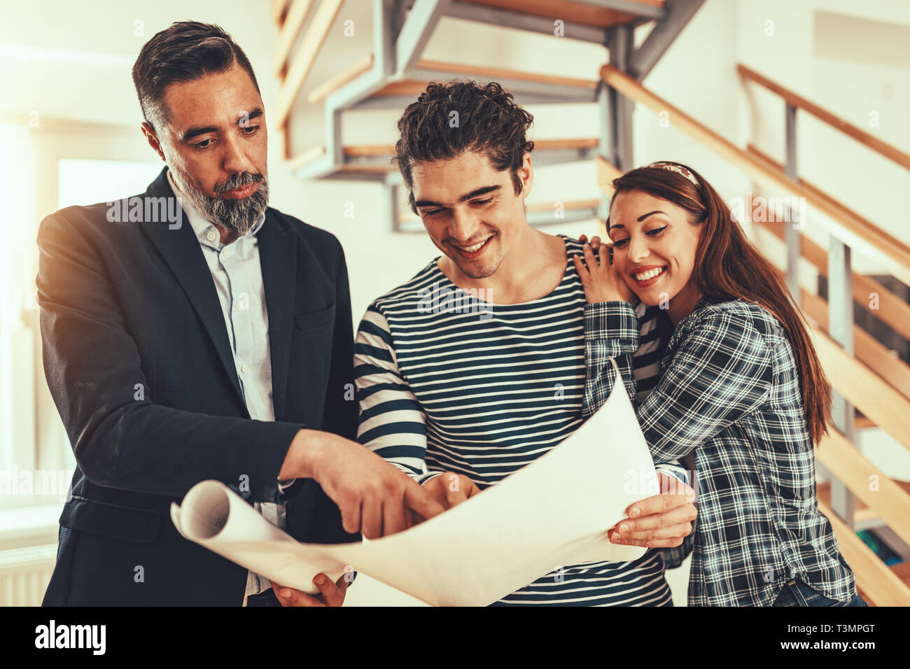 Estate agent is showing house to couple buyers, telling clients about ...