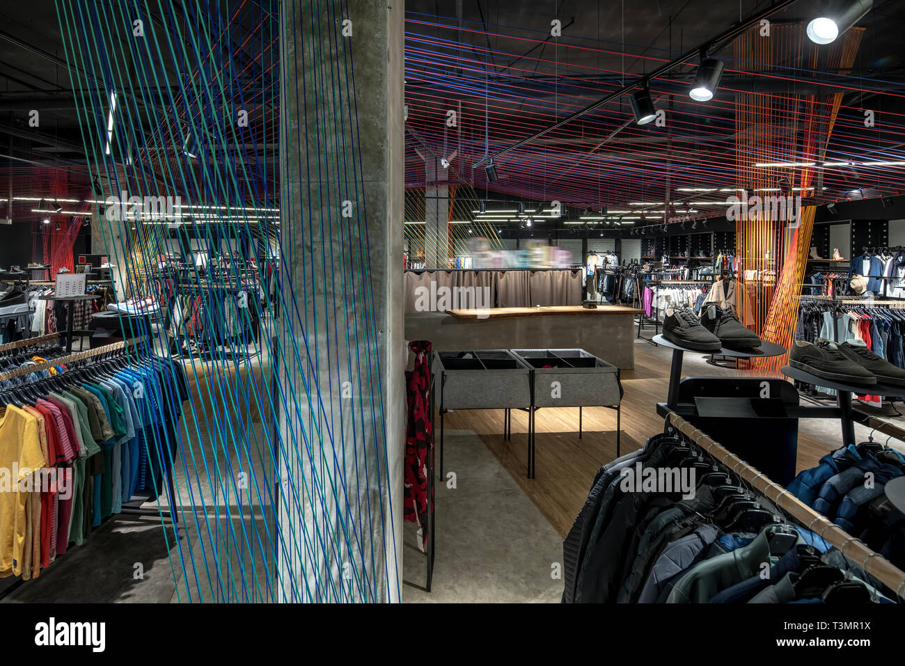 Modern clothes shop with large selection of different wear and shoes ...