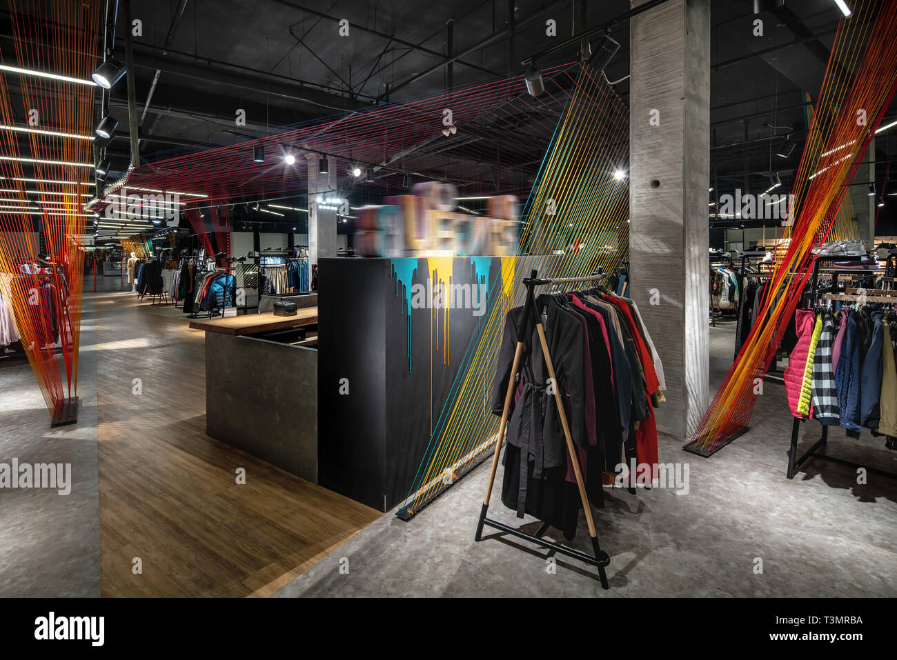 Modern clothes shop with large selection of different wear and shoes ...