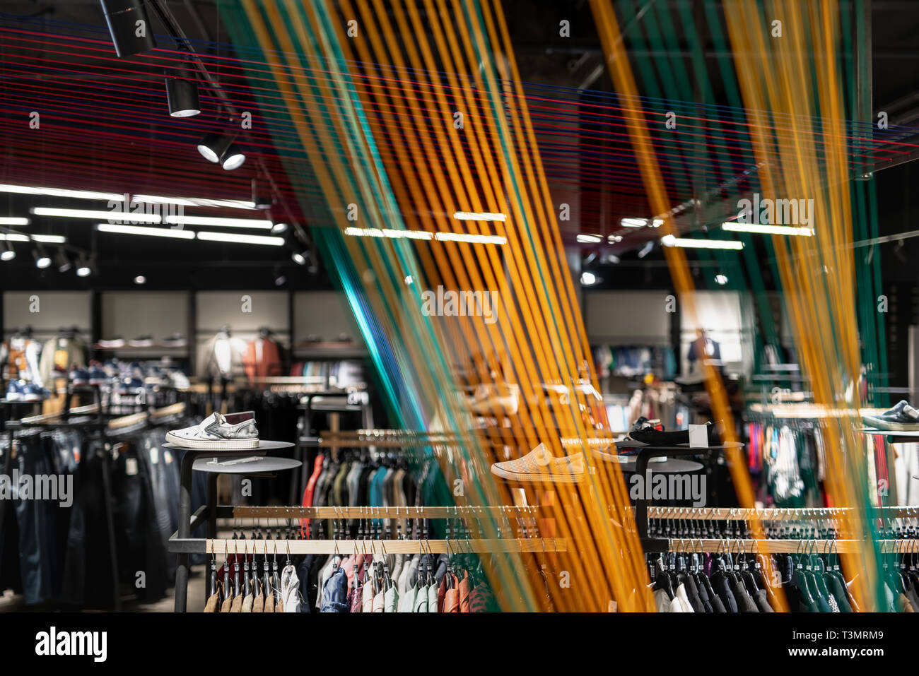 Modern clothes shop with large selection of different wear and shoes ...