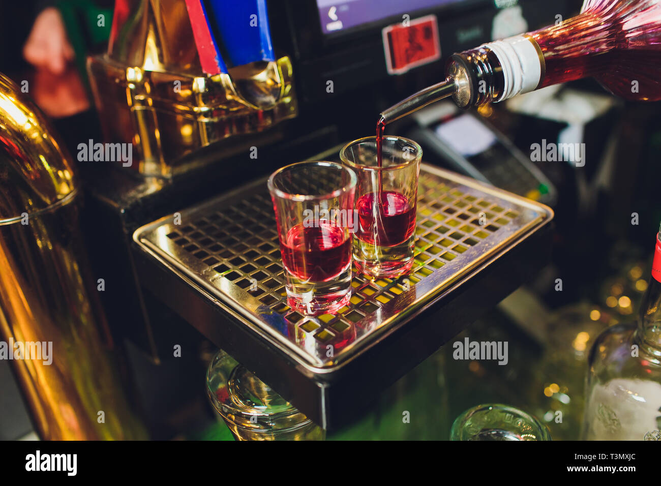 the man pours some brandy into a glass behind the bar Stock Photo - Alamy
