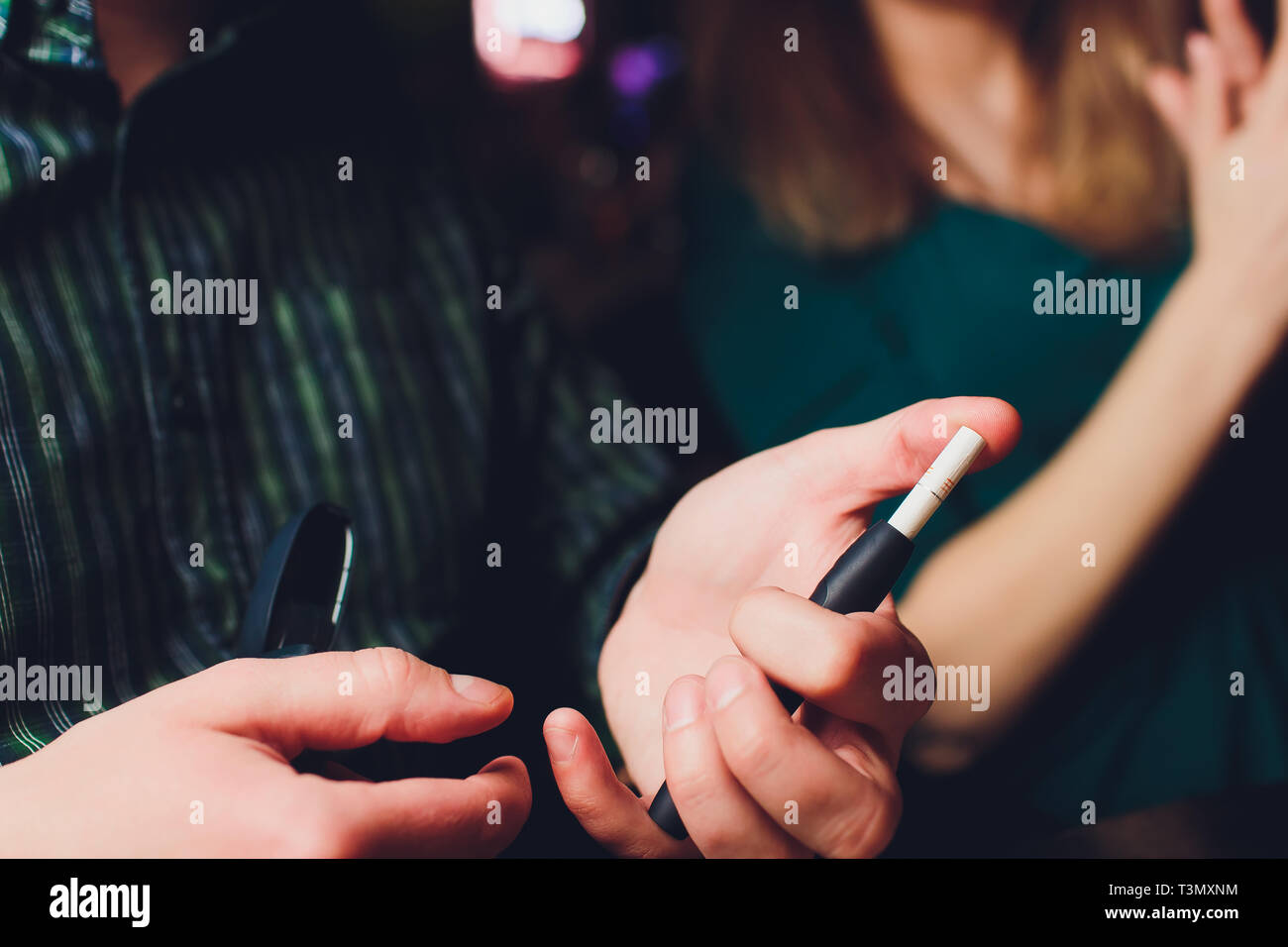 IQOS heat-not-burn tobacco product technology. Man holding e-cigarette ...