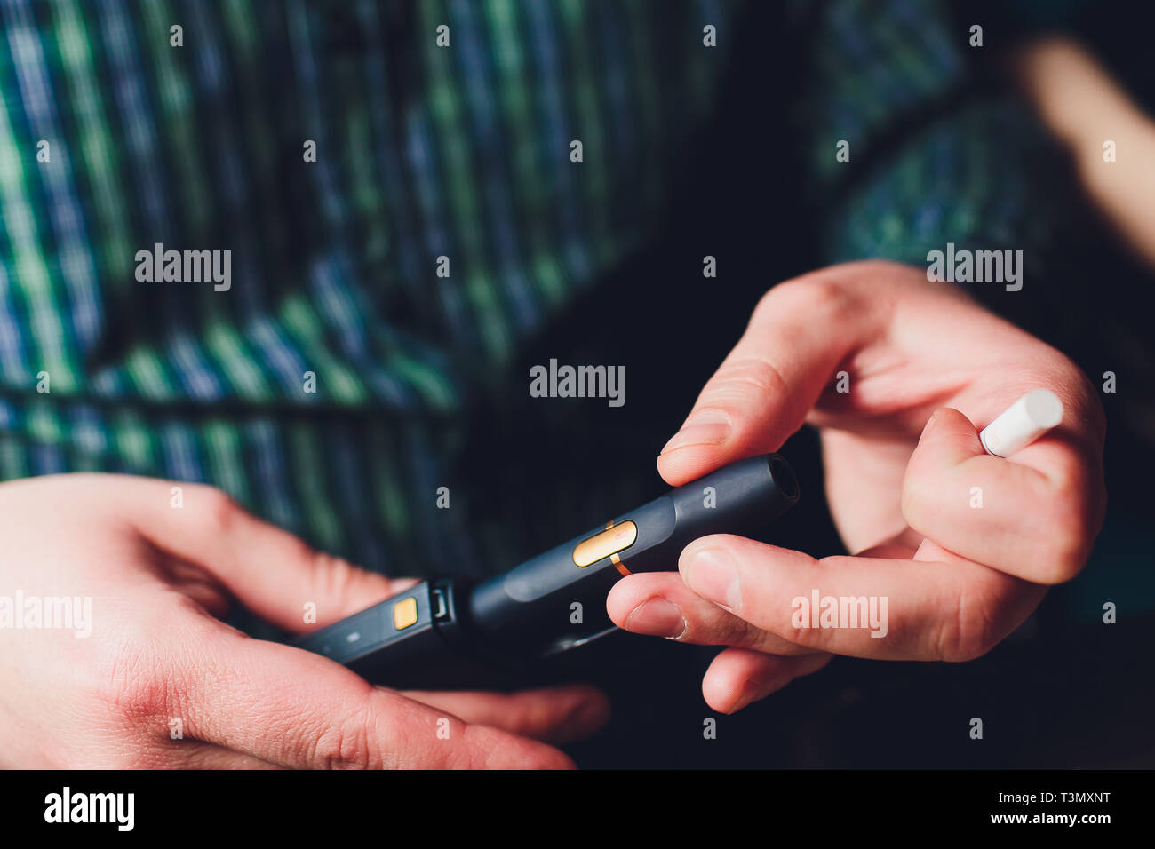 IQOS heat-not-burn tobacco product technology. Man holding e-cigarette ...