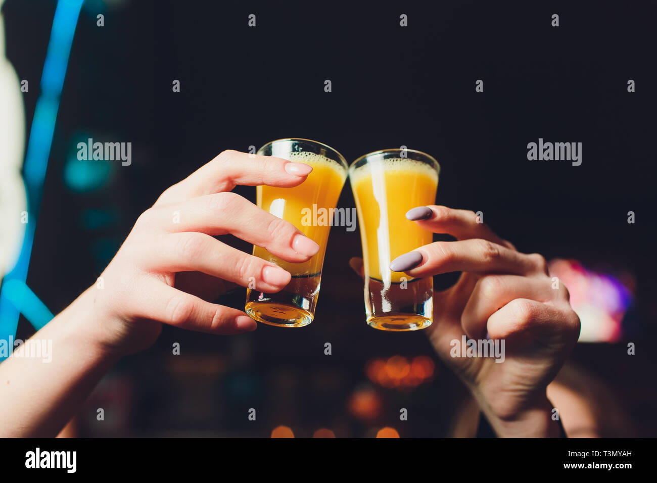 Closeup shot of friends toasting with cocktails. Young people drinking ...