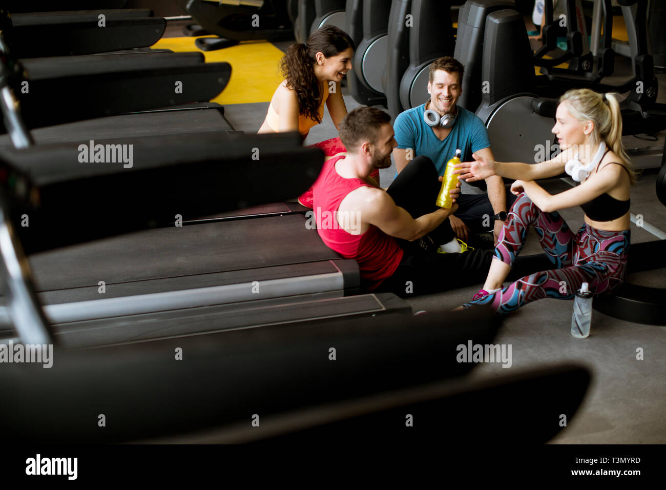 Group of young people in sportswear talking in a gym after a workout ...