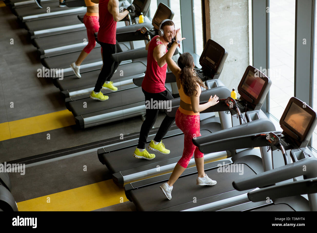 Man and woman doing cardio workout on treadmills in fitness club Stock ...