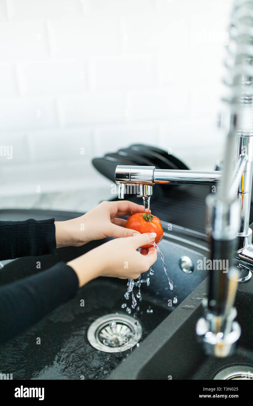 Washed tomatoes under running water in a professional kitchen Stock ...