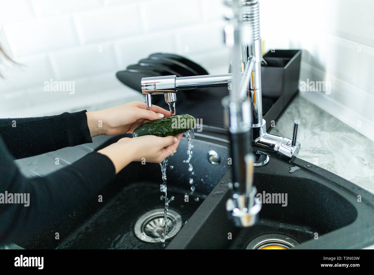 Woman washing cucumbers in kitchen sink Stock Photo - Alamy