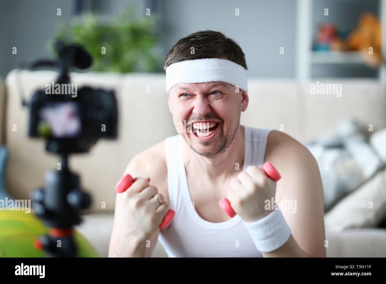 Male vlogger holds dumbbells in his Stock Photo - Alamy
