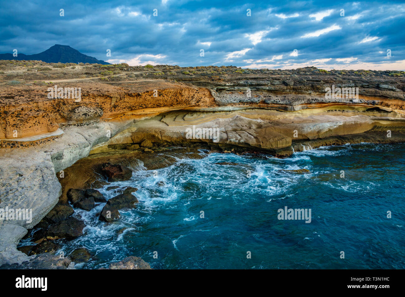 Cove at sunset with cloudscape and rocks Stock Photo - Alamy