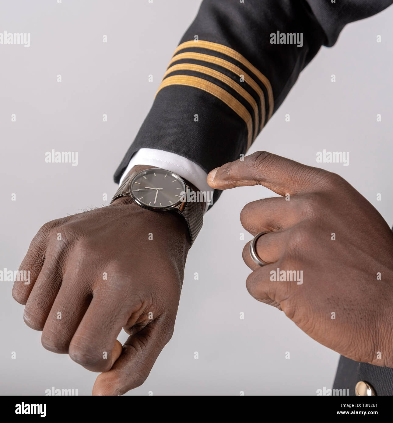 England, UK, April 2019. Airline pilot checking time on his wristwatch ...