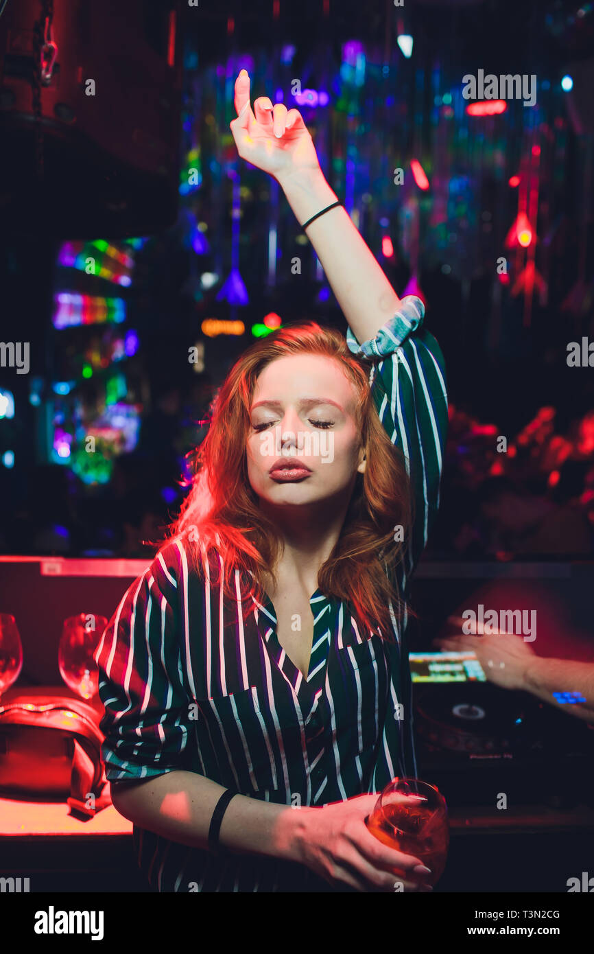 Happy woman dancing in the night club with drinks in the hand Stock ...