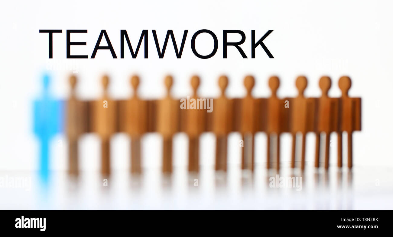 Teamwork sign above line of toy human figures Stock Photo - Alamy