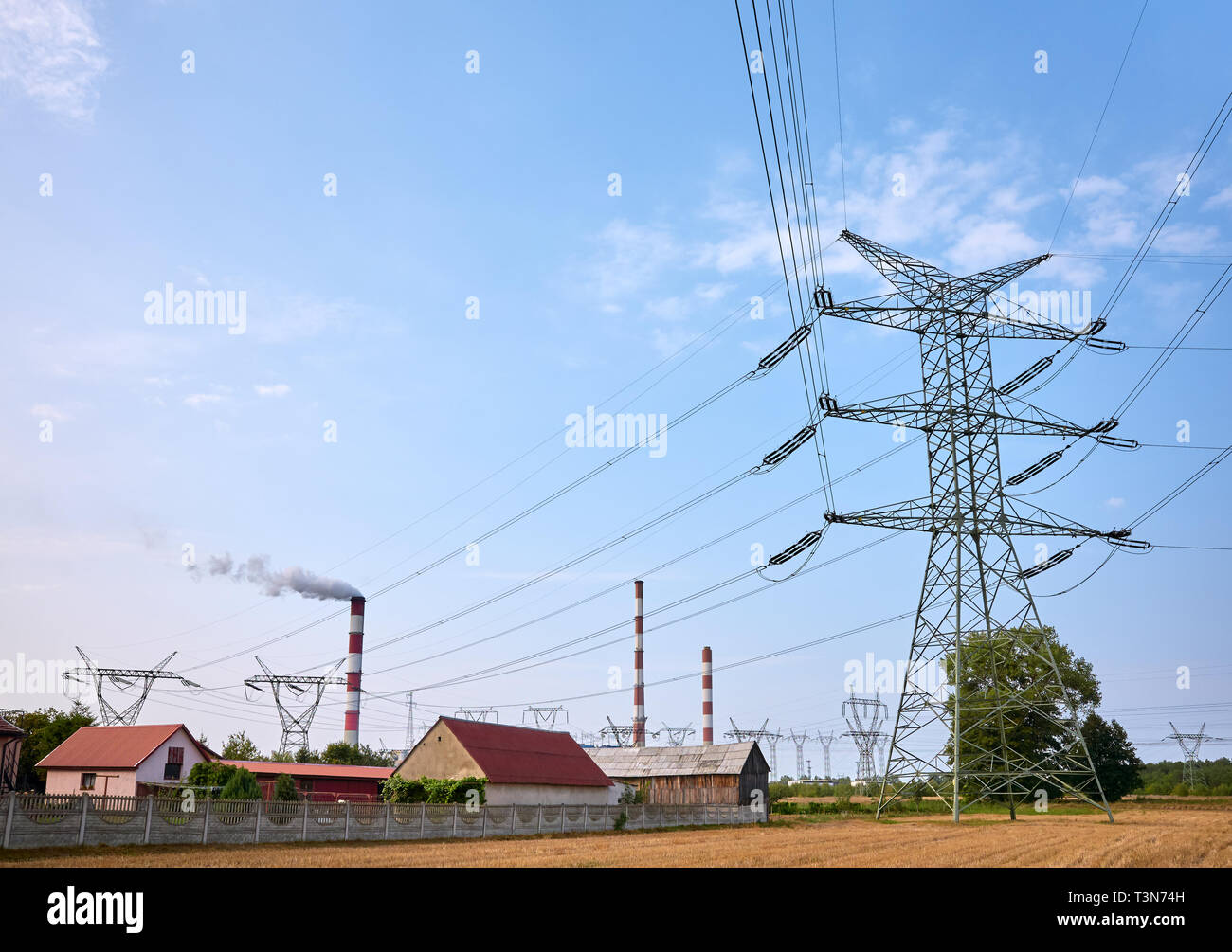 Transmission towers and power plant chimneys in the countryside Stock ...