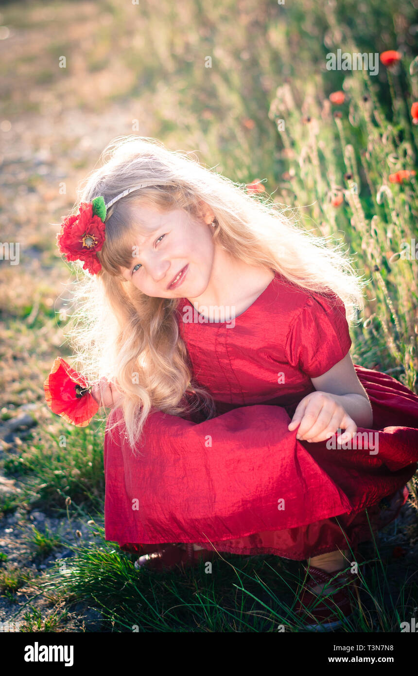 beautiful blond girl with red corn poppy flower Stock Photo - Alamy