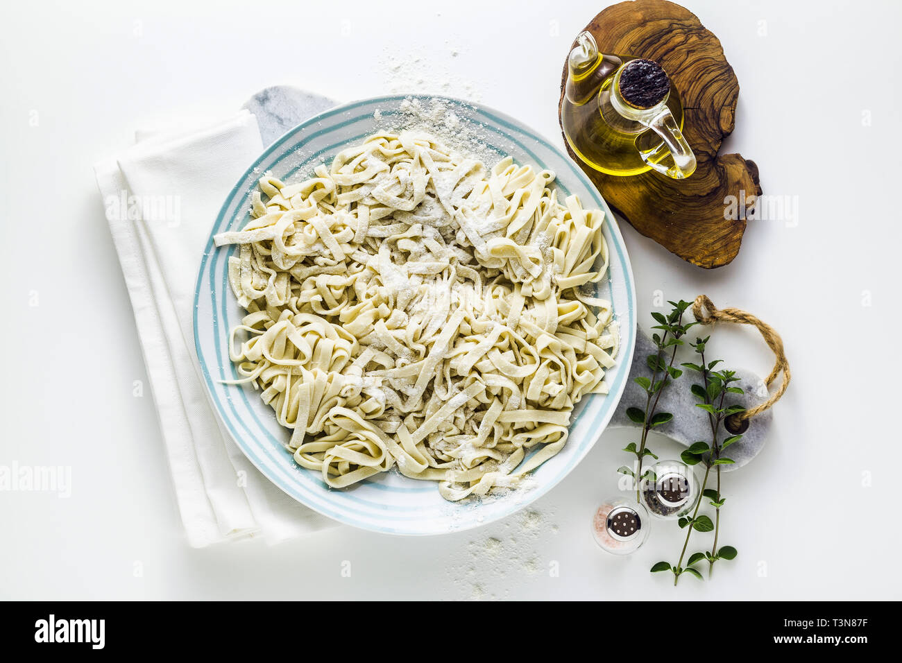 Fresh homemade tagliatelle pasta ready to be cooked. on a white table ...