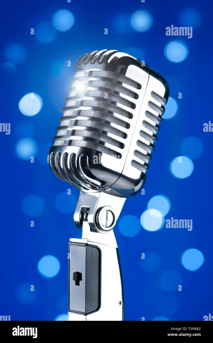 Retro style microphone on stage light background with defocused lights ...