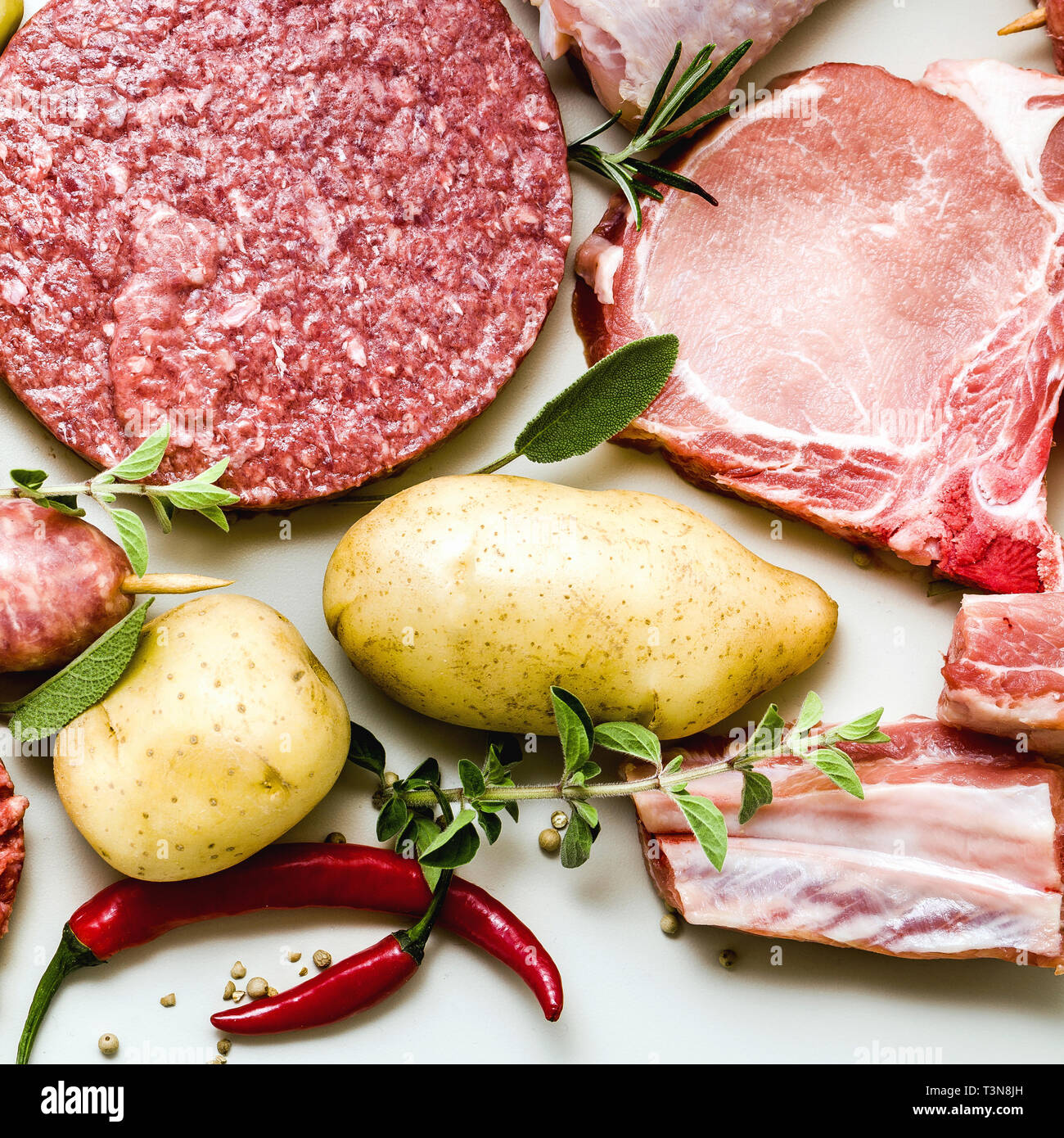different types of raw meat: chicken thighs, pork and beef burgers ...