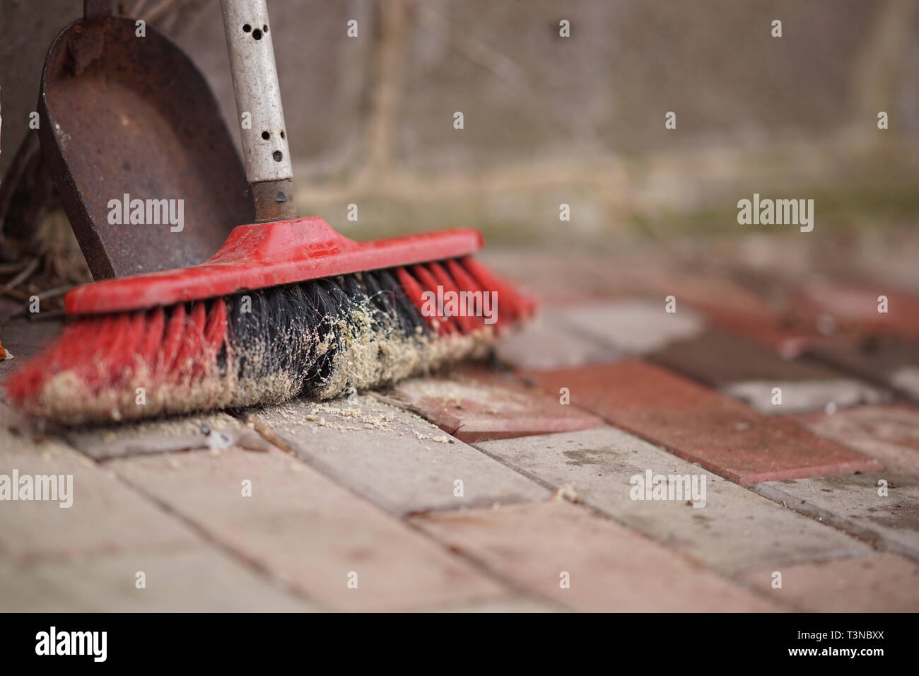 Red plastic broom clogged with sand standing on the tile Stock Photo ...