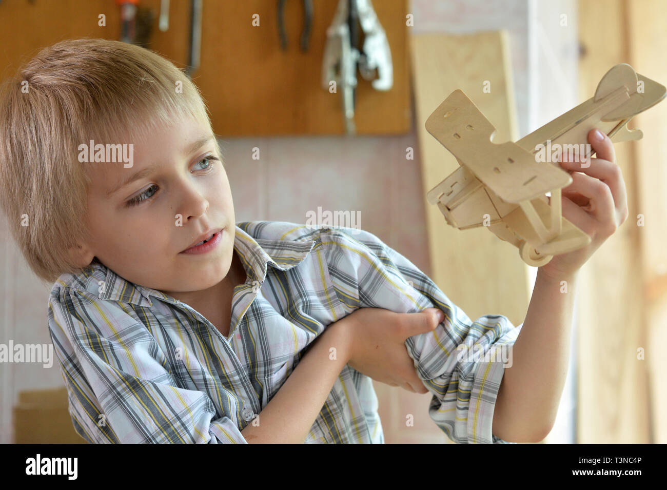 Cute little boy working with wood in workshop at home Stock Photo - Alamy