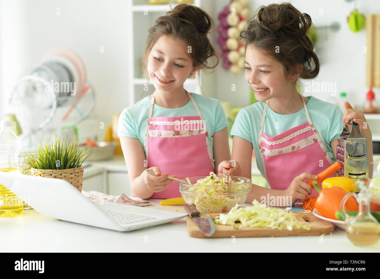 Two girls sisters in the kitchen cook Stock Photo - Alamy