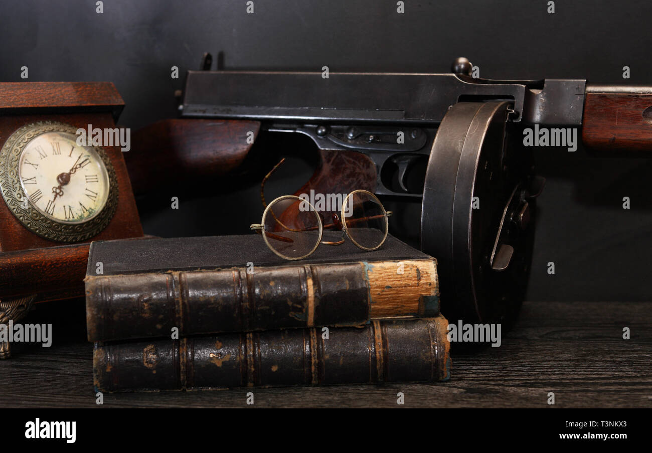 Vintage still life with clock and old USA submachine gun on dark ...