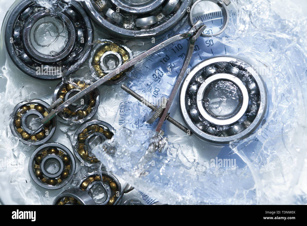 Machinery concept. Closeup set of ball bearings under frozen water ...