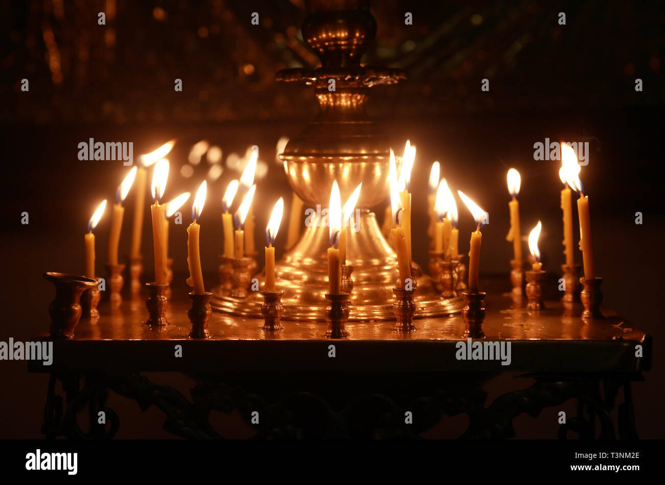 Christianity church interior. Set of lighting candles on dark ...