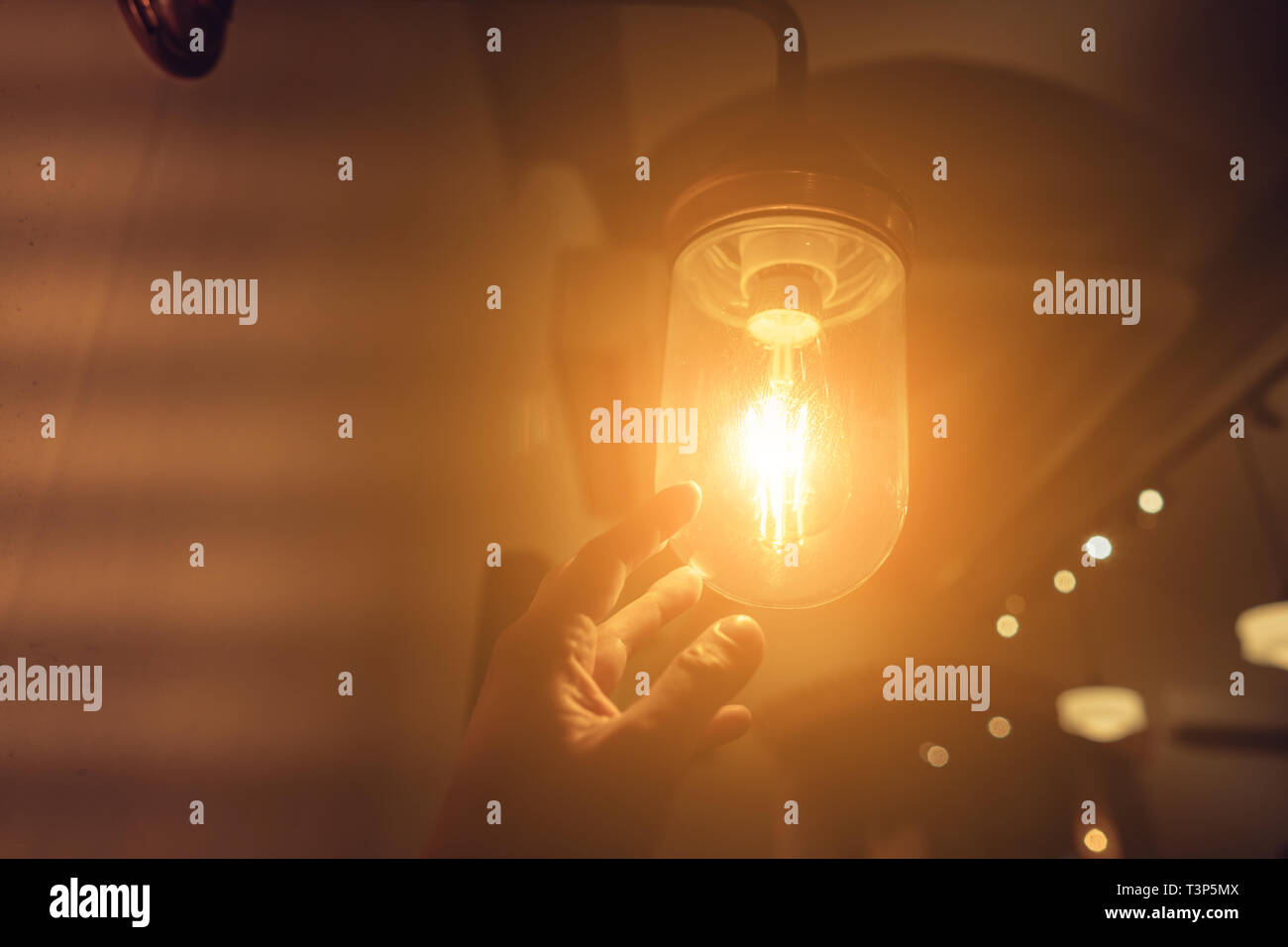 Hand reaching for a vintage light bulb Stock Photo - Alamy
