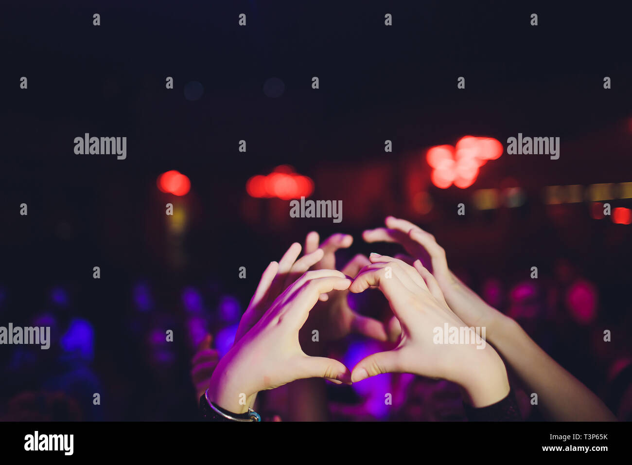 Silhouette of a heart shaped hands shadow of Audience Crowd people in ...
