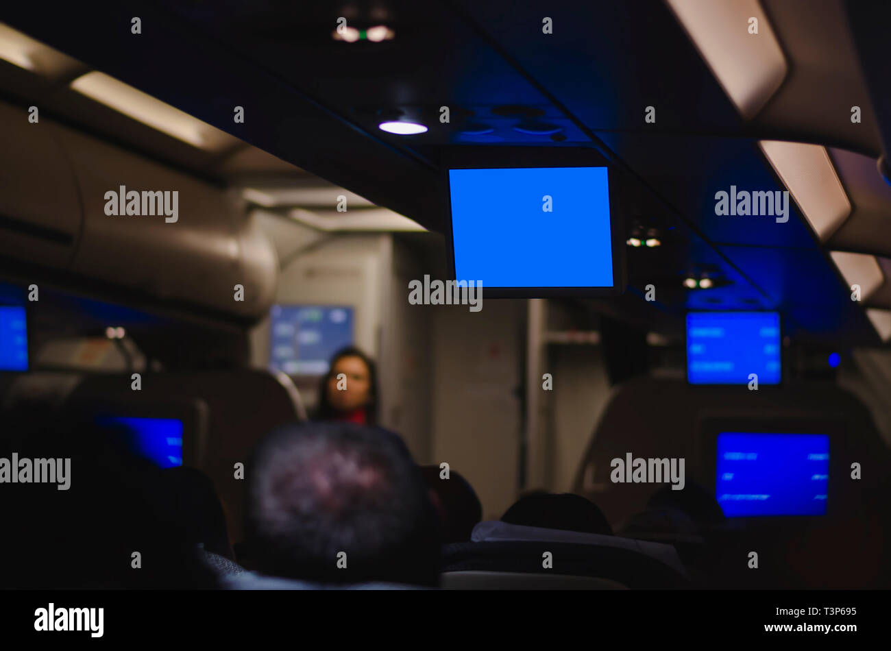 Inside an airplane during a flight with the informative tv screens down ...