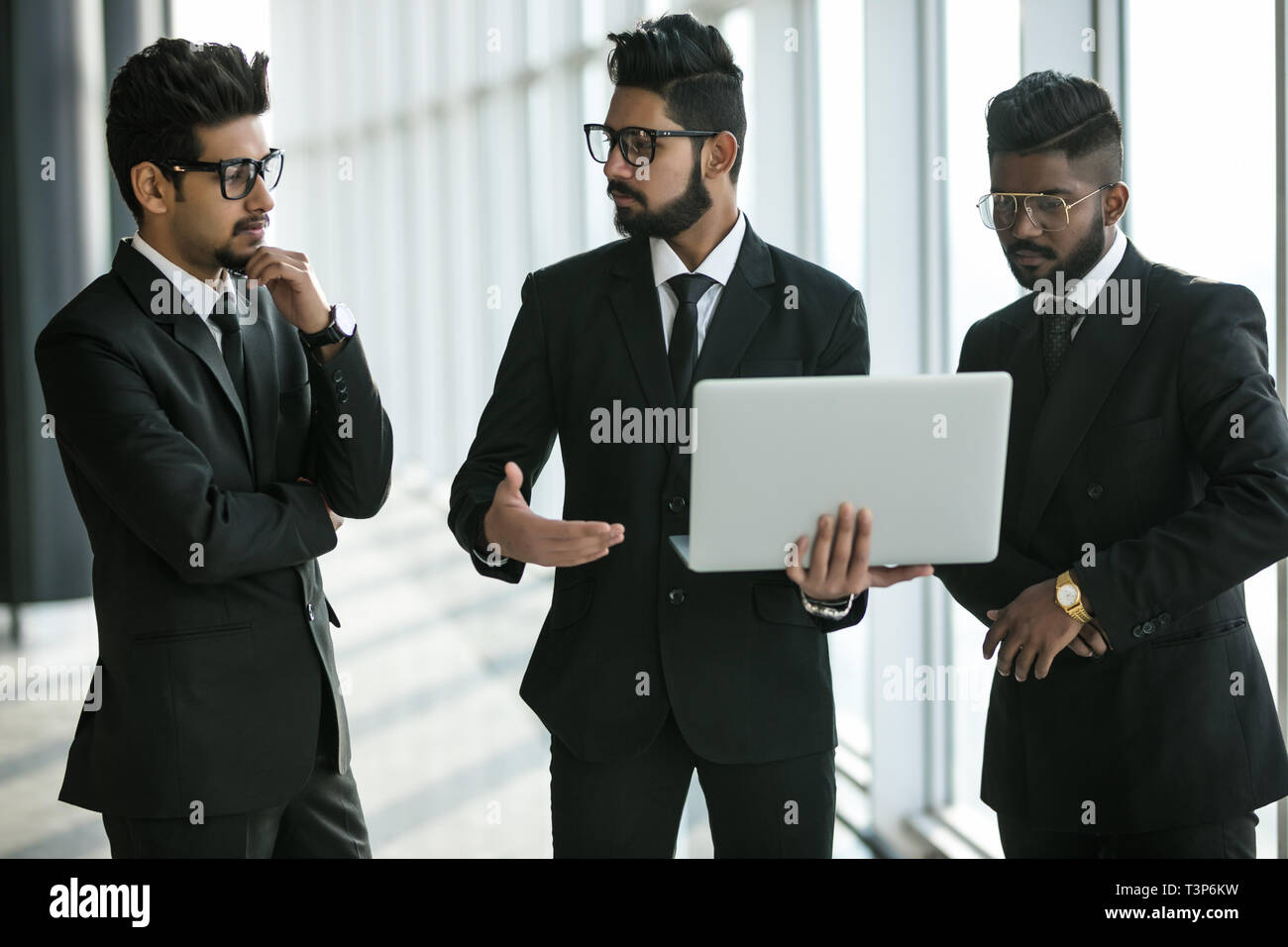 silhouettes of three asian corporate executives standing in front of ...
