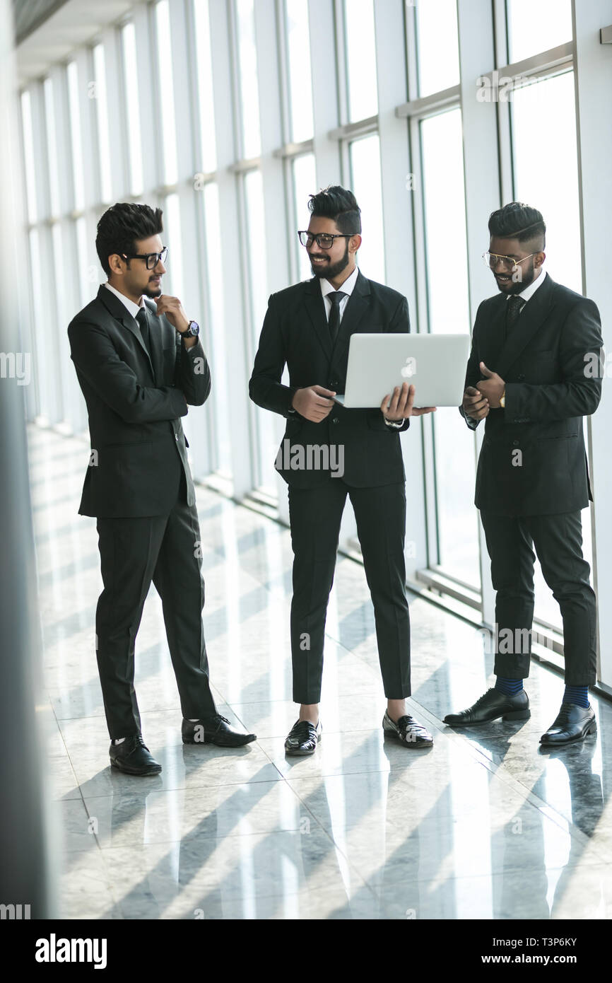 silhouettes of three asian corporate executives standing in front of ...