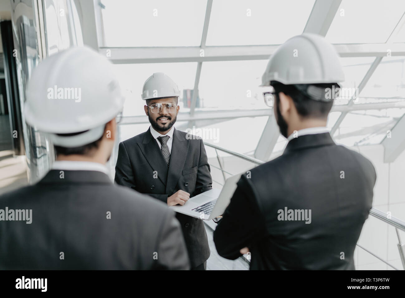 Engineering men with paper and hardhat working indoors in building ...