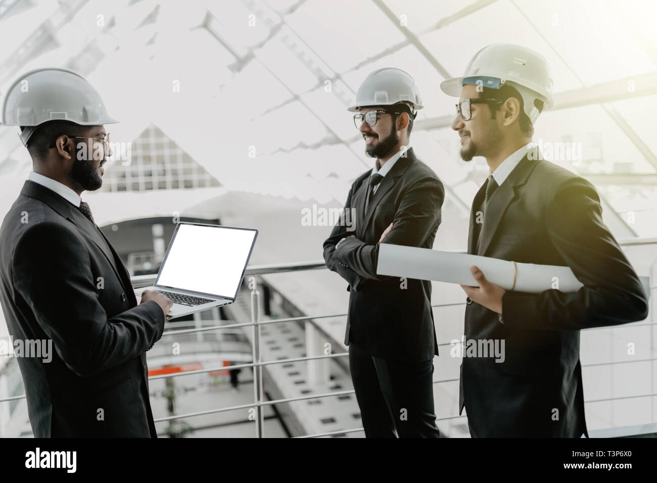 Engineering men with paper and hardhat working indoors in building ...