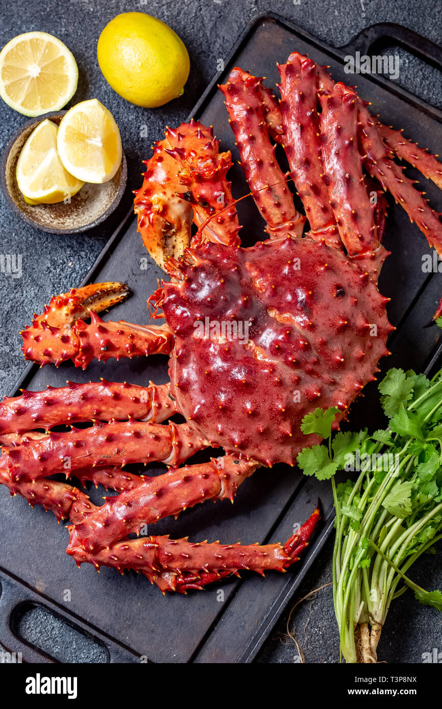 Red king crab on gray background. King crab, lemon and cilantro, top ...