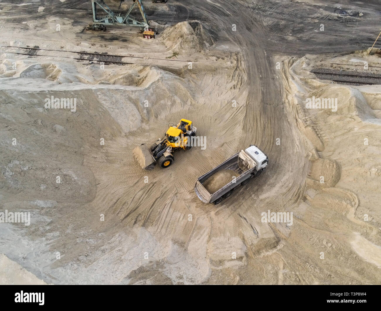 Big heavy wheel loader loading sand into dump truck in sand pit. Heavy ...