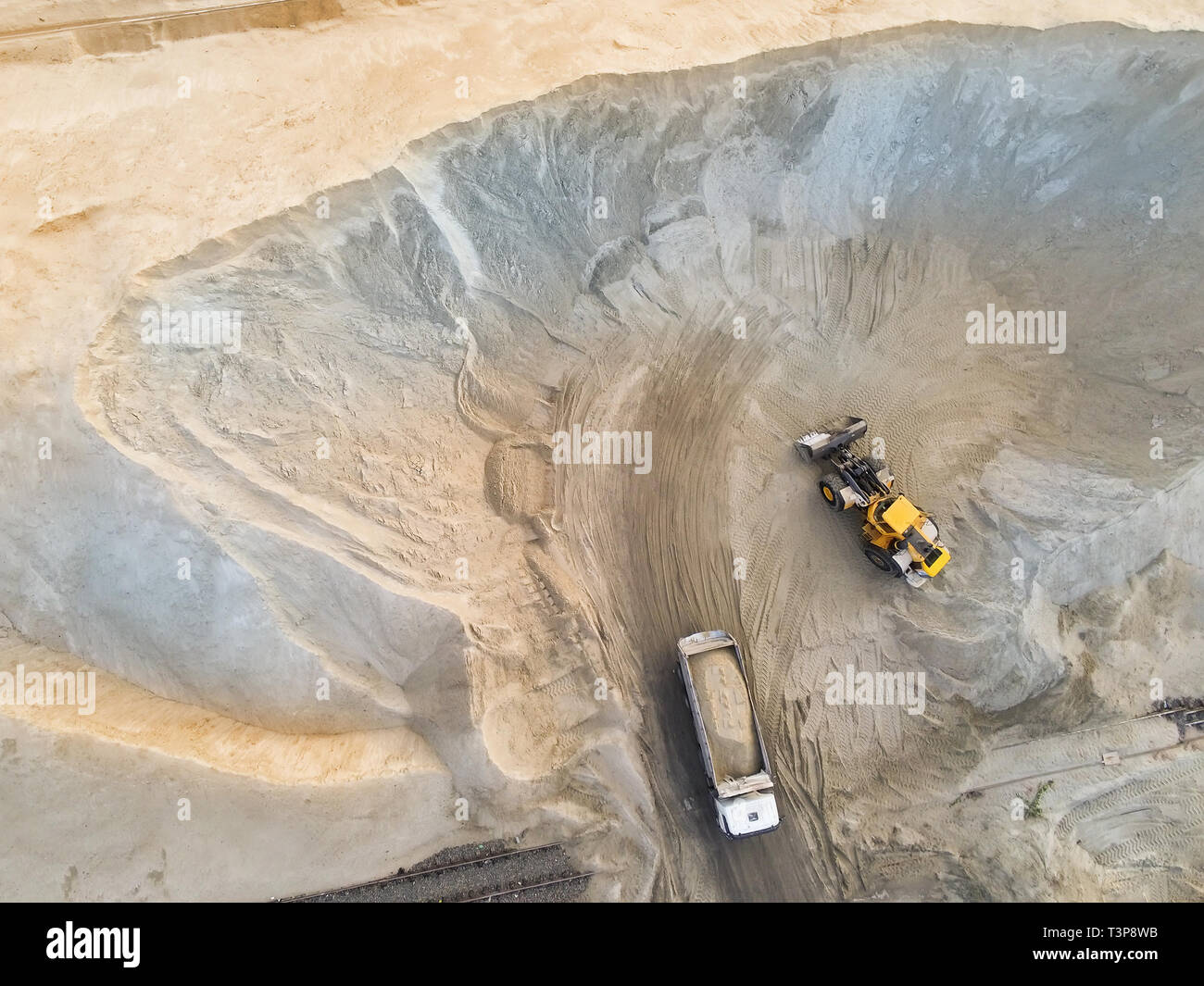 Big heavy wheel loader loading sand into dump truck in sand pit. Heavy ...