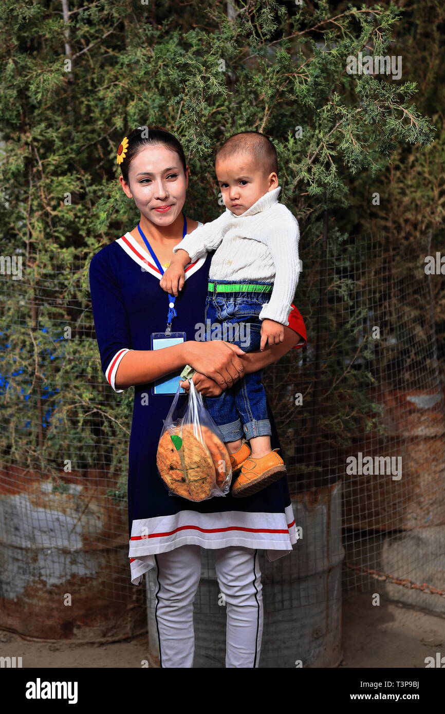 Uyghur young mother and son with nang bread. Hotan-Xinjiang-China-0096 ...