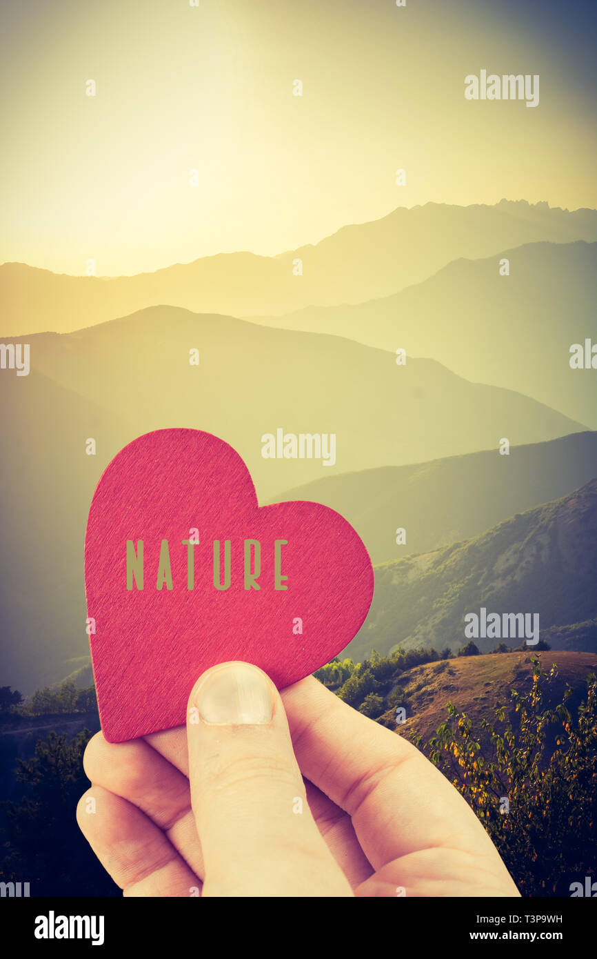 Hand holding a heart shape with nature wording on landscape Stock Photo ...